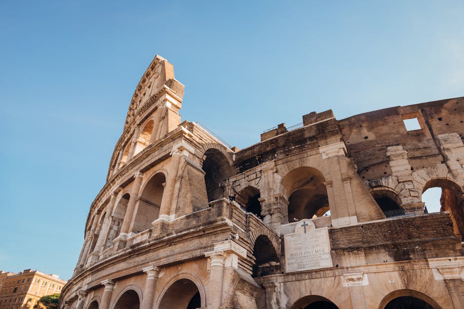 Side angle view of the Roman Colosseum under clear blue skies