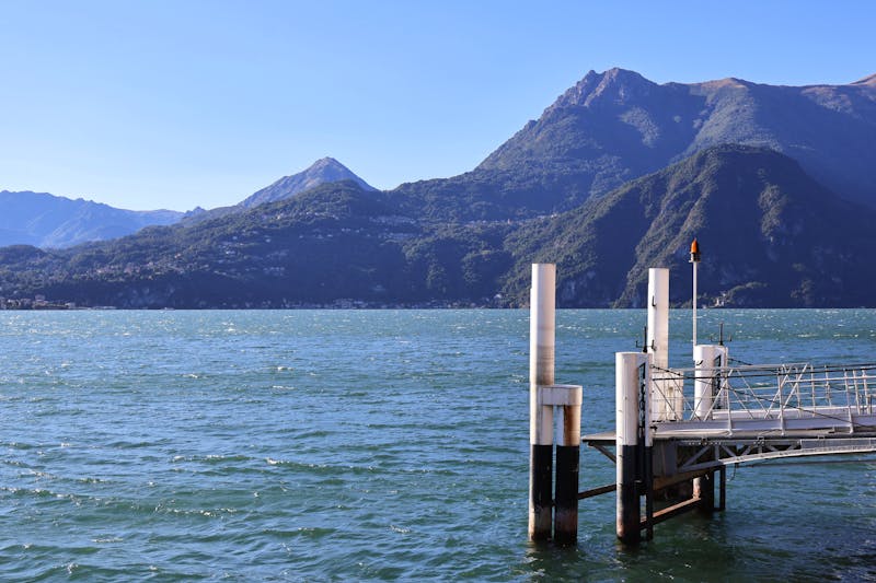 A pier on Lake Como with Alpine mountains in the background