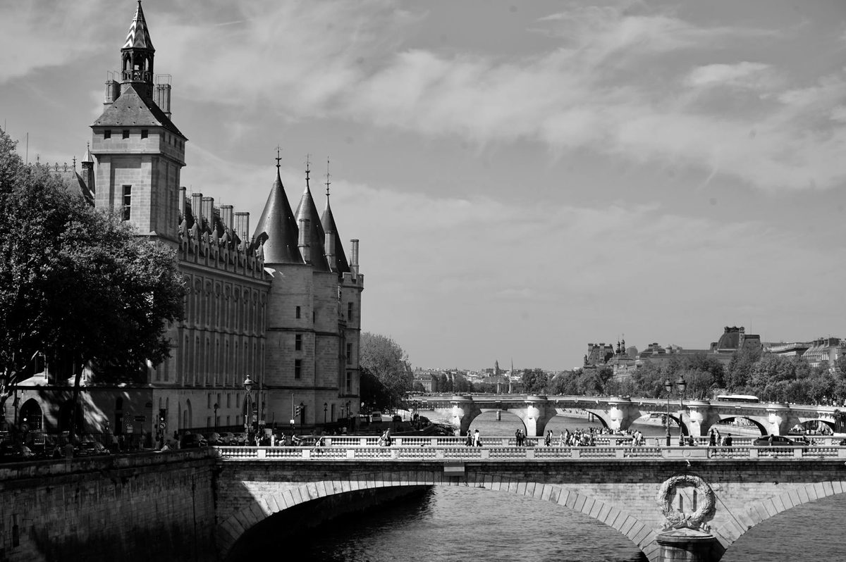 Black and white view of the Conciergerie palace and bridge in Paris