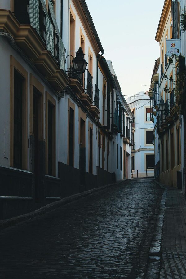 A picturesque narrow street with whitewashed walls in Cordoba at sunset
