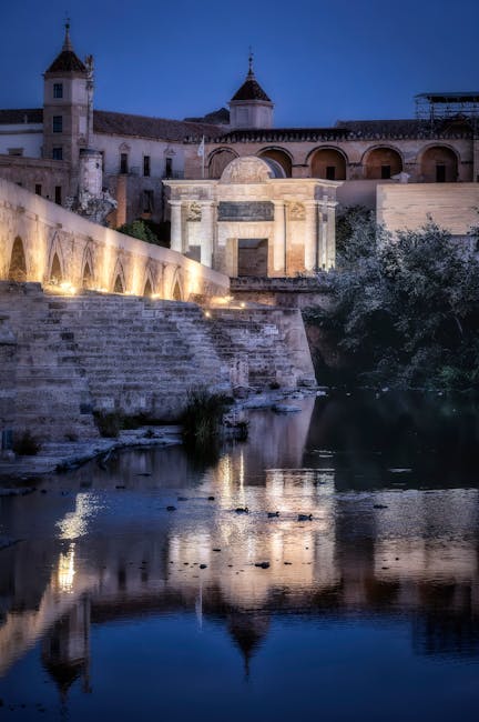 Cordoba Roman Bridge illuminated at night with reflections in the Guadalquivir river