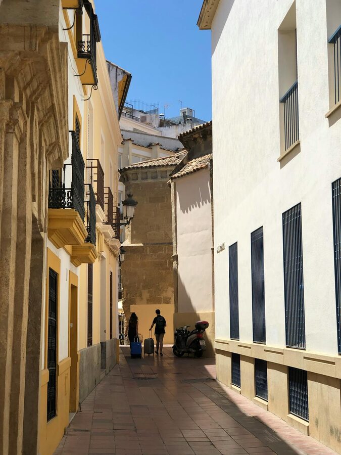 Sunlit alleyway in the historic center of Cordoba with whitewashed walls