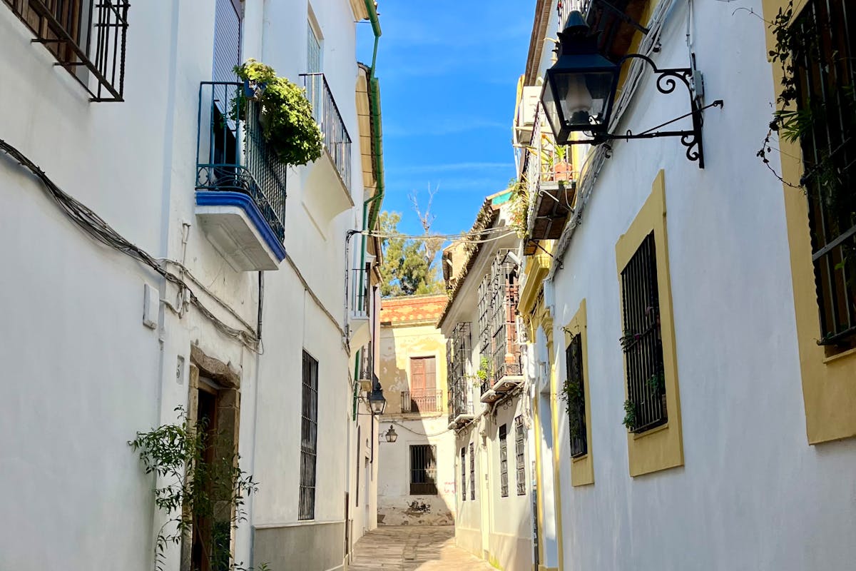 A whitewashed alley in Cordoba under bright blue sky
