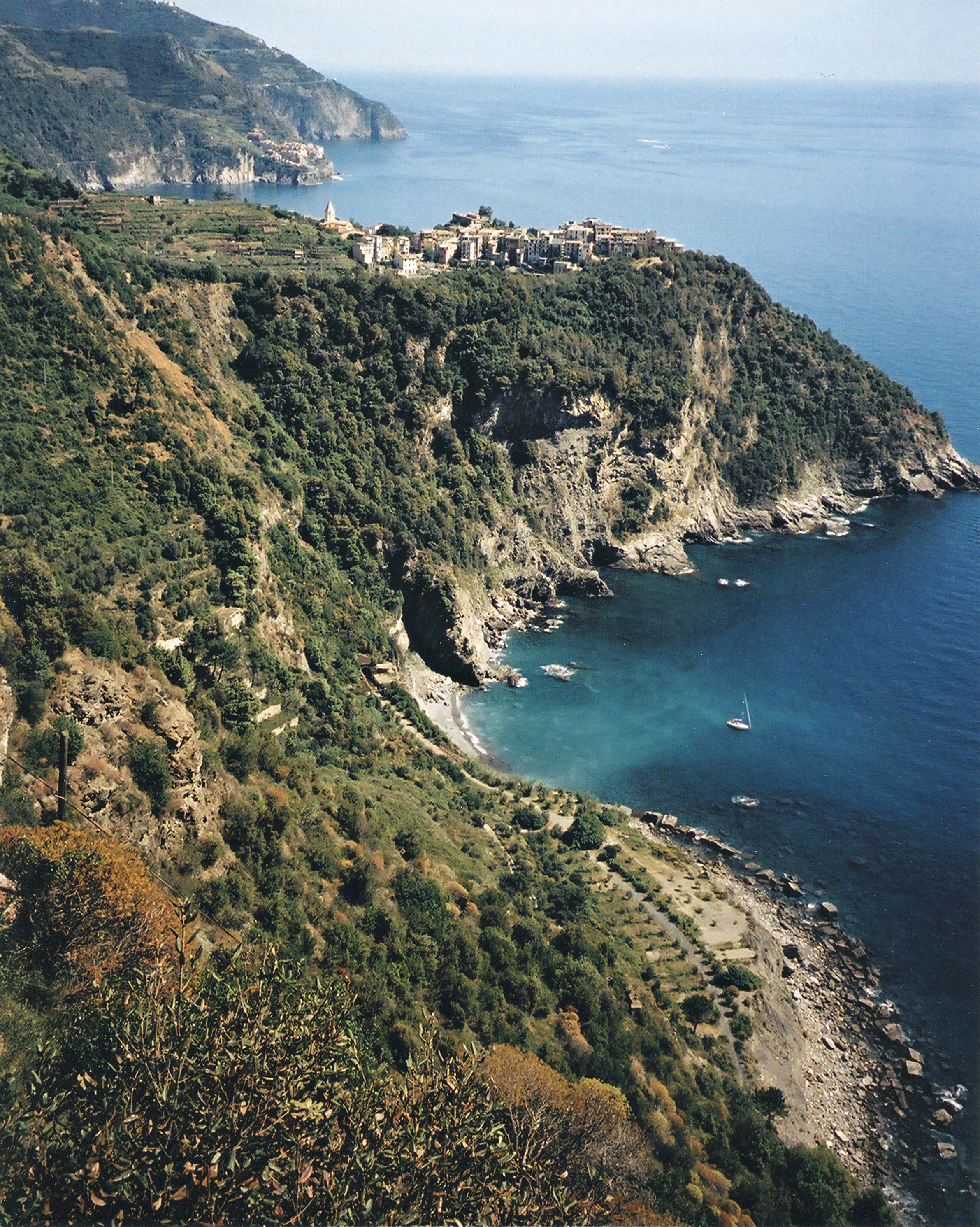 The village of Corniglia sitting high atop a steep cliff above the Ligurian Sea, viewed from below
