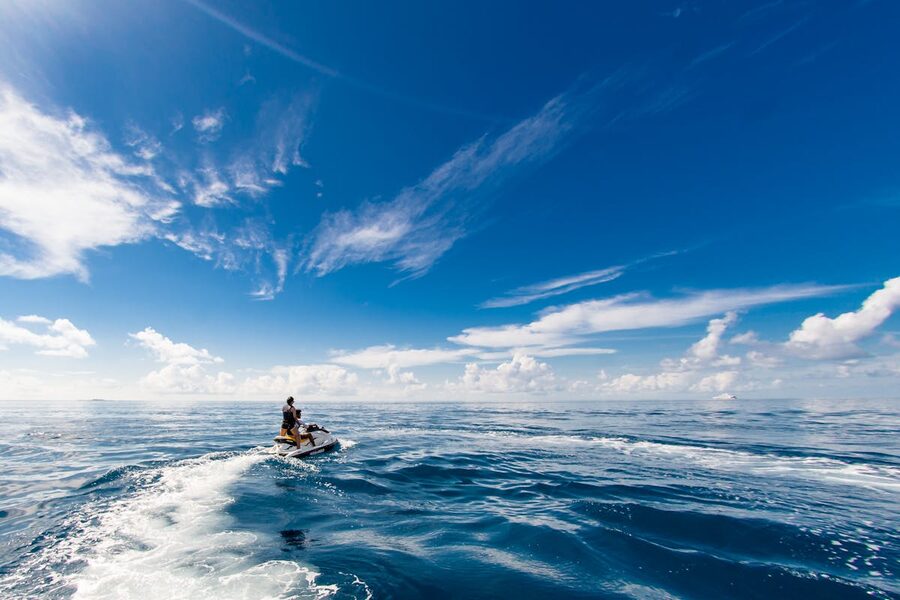 Two people riding a jet ski in tropical waters