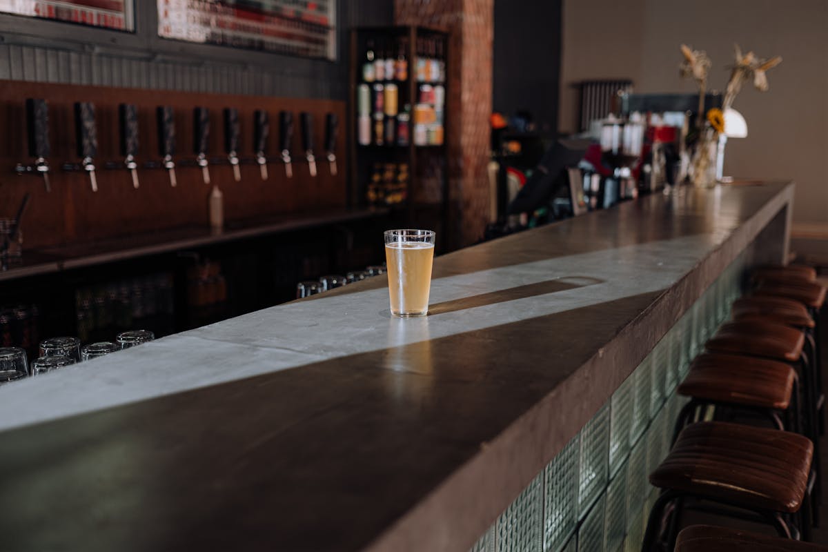Glass of craft beer on a sleek bar counter in a modern pub
