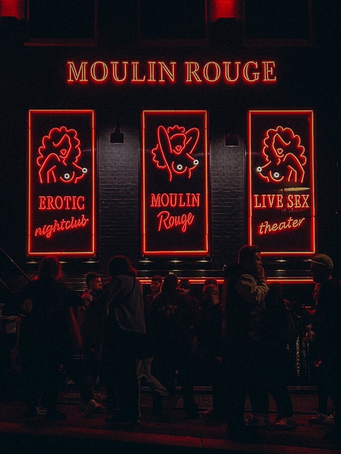 Crowd outside an iconic nightlife venue with bright neon sign
