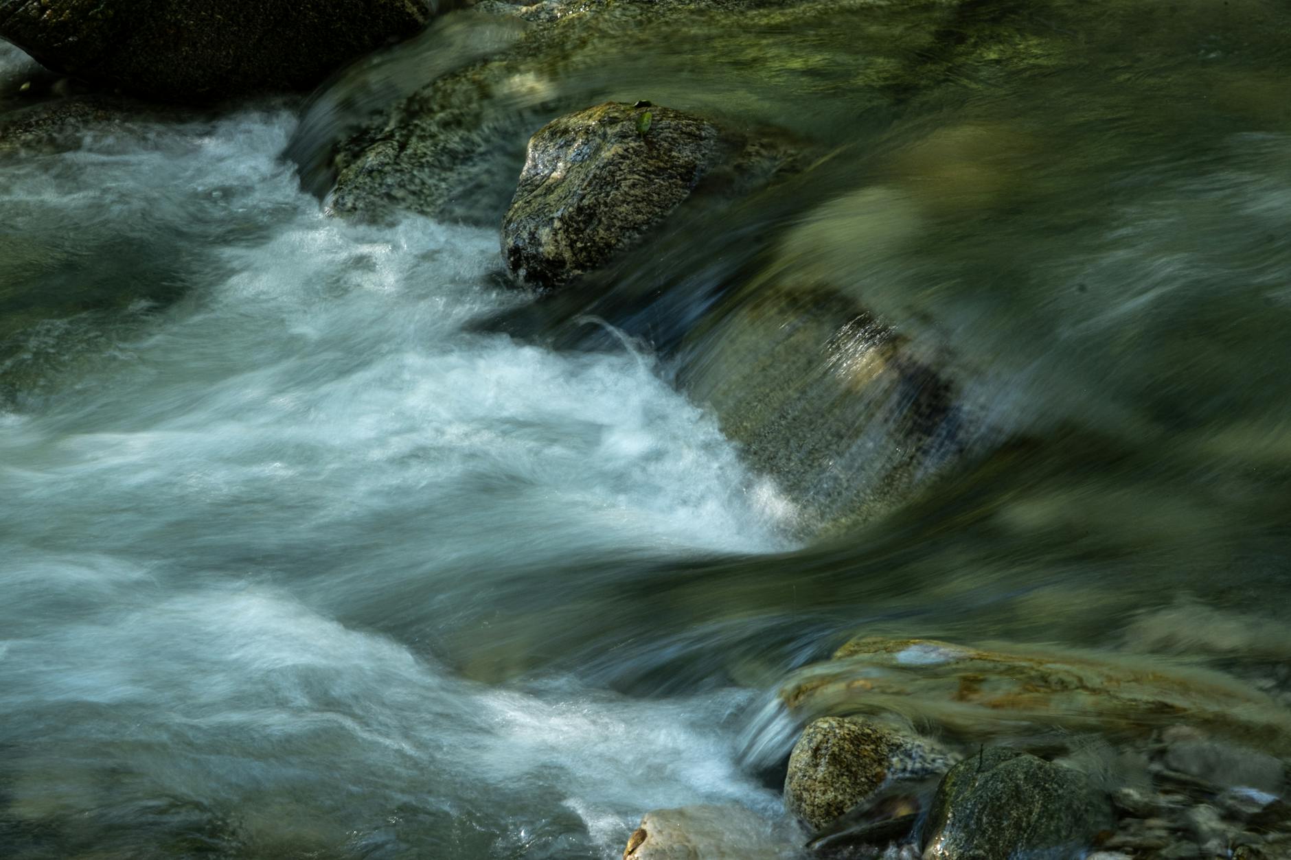 Clear mountain stream flowing over mossy rocks