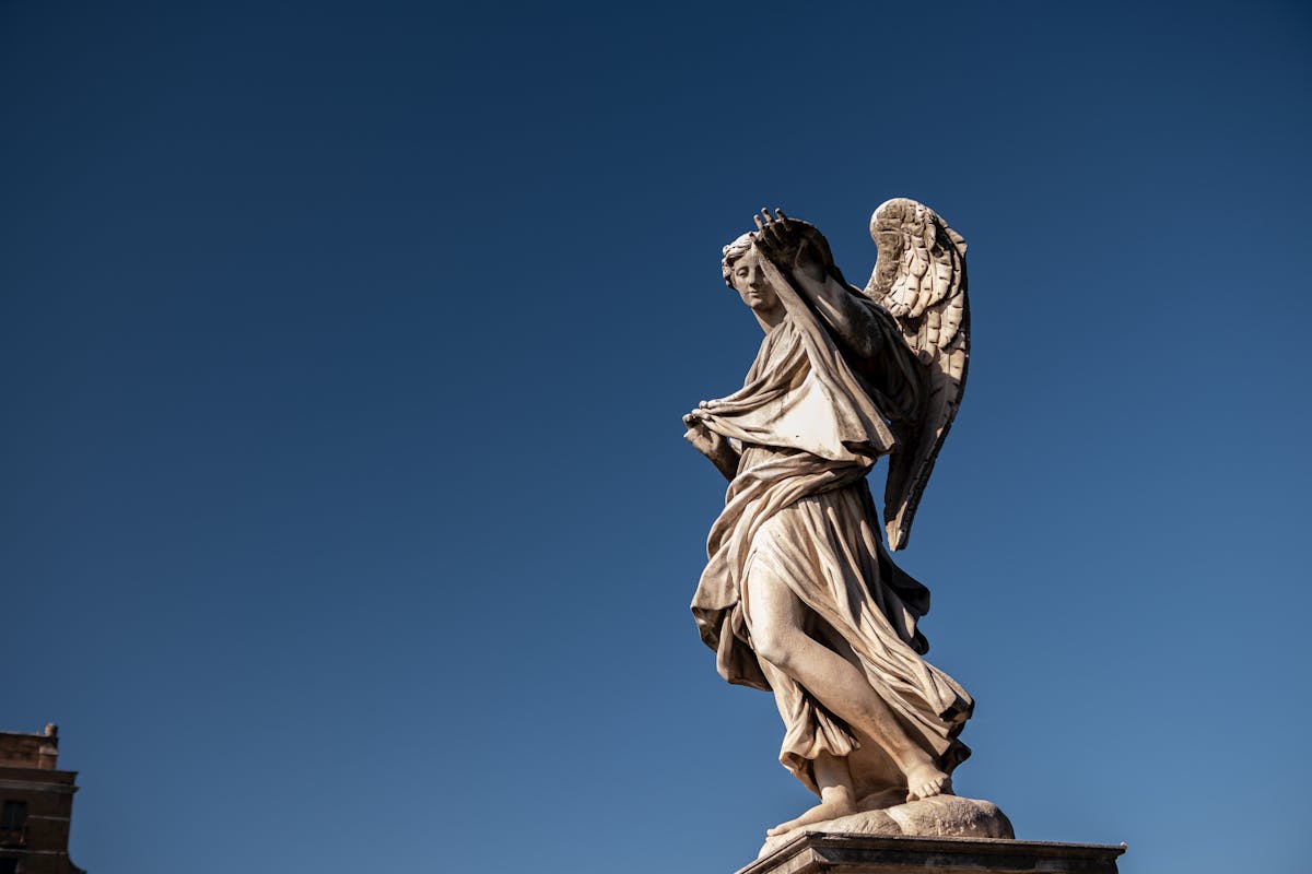 Dramatic angel statue against blue sky at Castel Sant Angelo in Rome