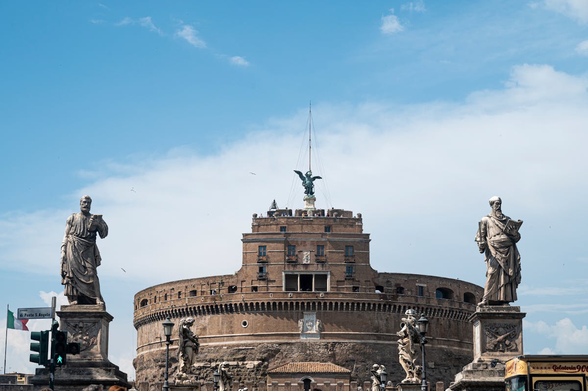 Dramatic view of Castel Sant Angelo with imposing statues and clear blue sky in Rome