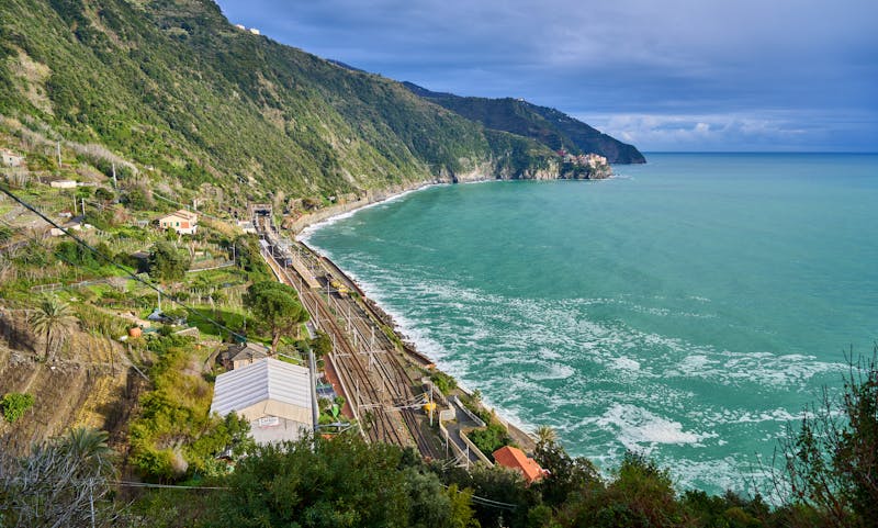 Aerial view of the dramatic Cinque Terre coastline with the railway line hugging the cliffs above turquoise sea