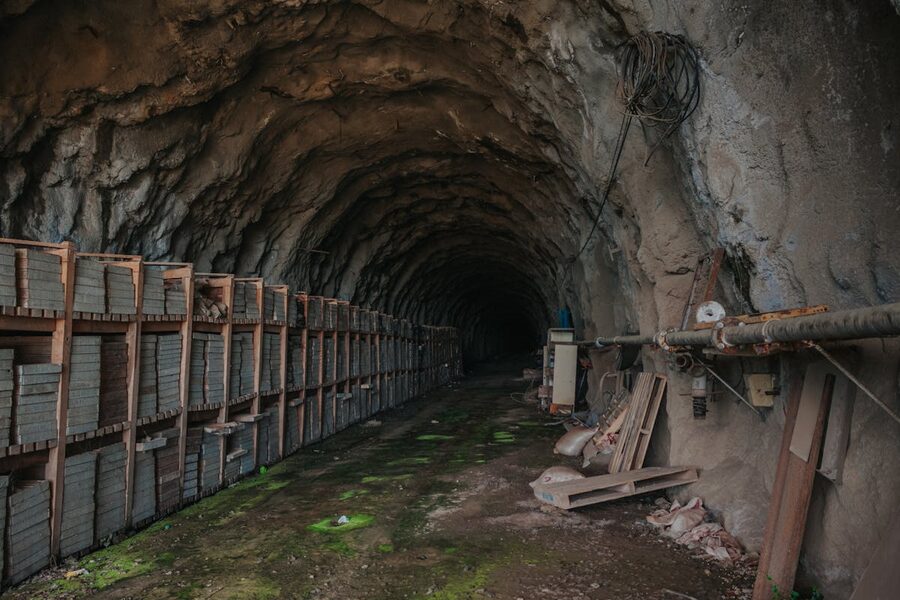 Dark underground tunnel with stored materials and industrial elements