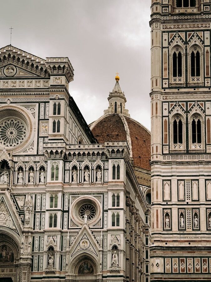 View of Florence cathedral dome framed by natural foliage under a clear sky