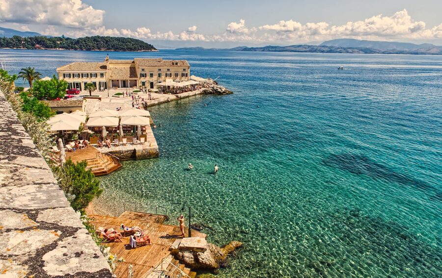 Discover the picturesque charm of Corfu Island's historic waterfront, nestled by clear blue waters and ancient architect