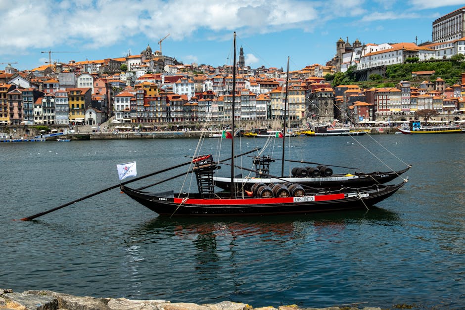 Traditional rabelo boat on the Douro River with Porto skyline in background