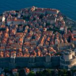 Aerial view of Dubrovnik Old Town with medieval castle walls and terracotta rooftops along the Adriatic coast