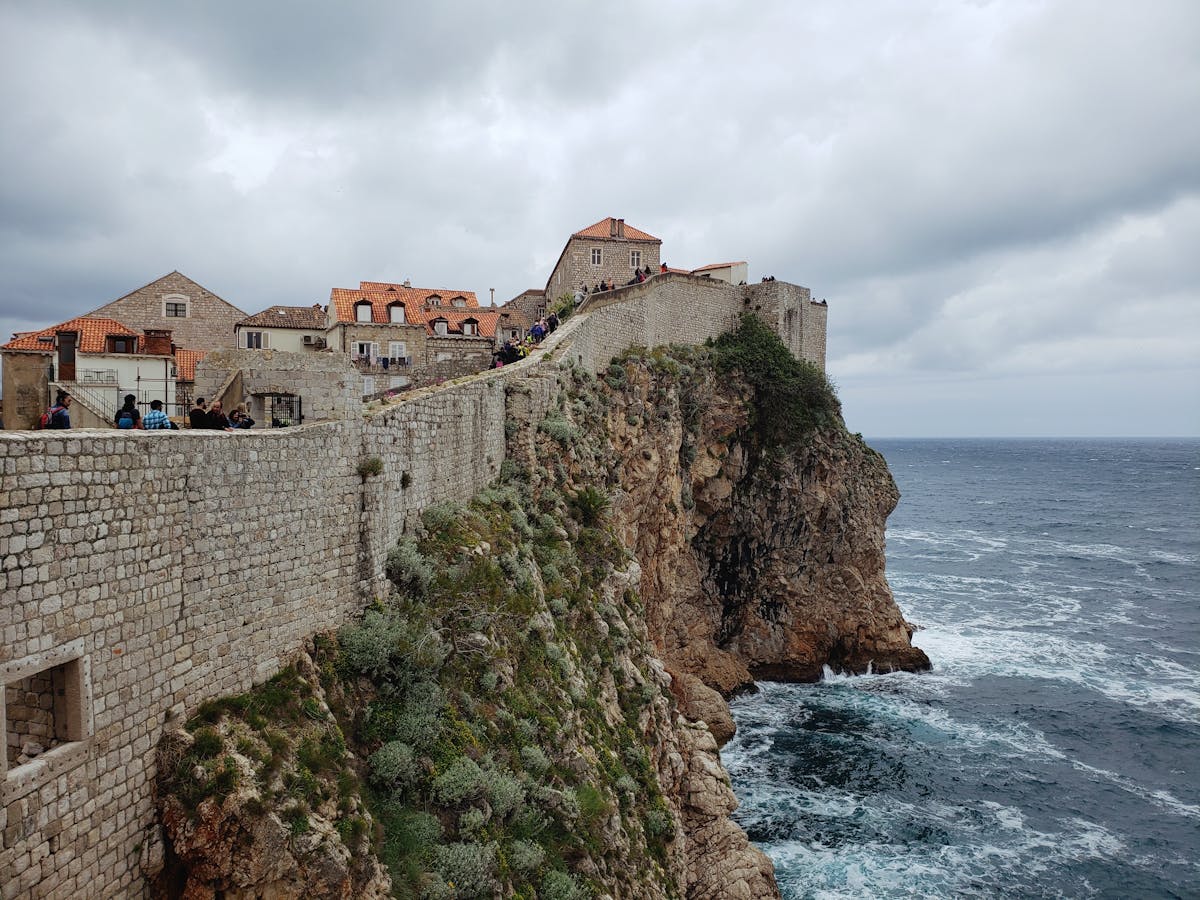 Dubrovnik city wall on cliff above the blue Adriatic Sea