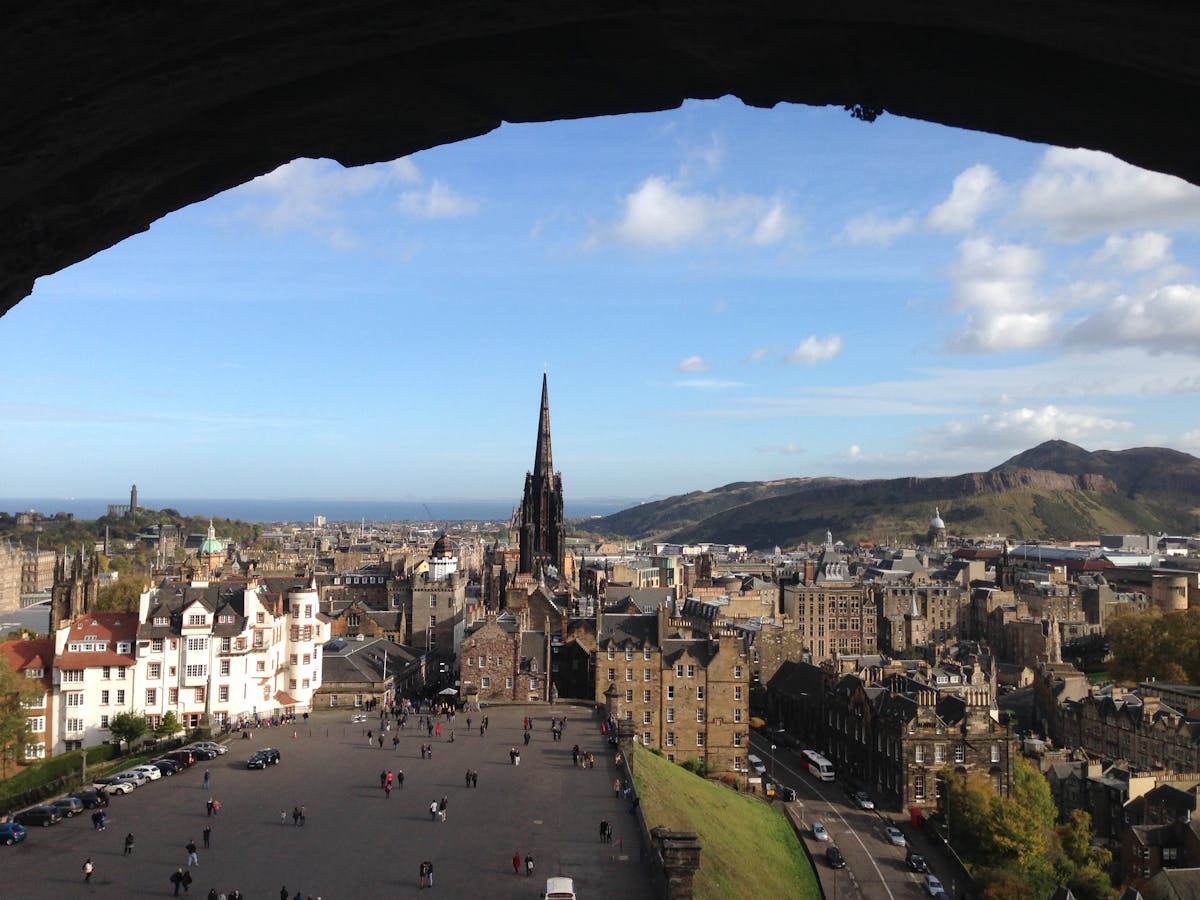 Breathtaking view of Edinburgh cityscape from the castle showing historic buildings and distant hills under grey skies