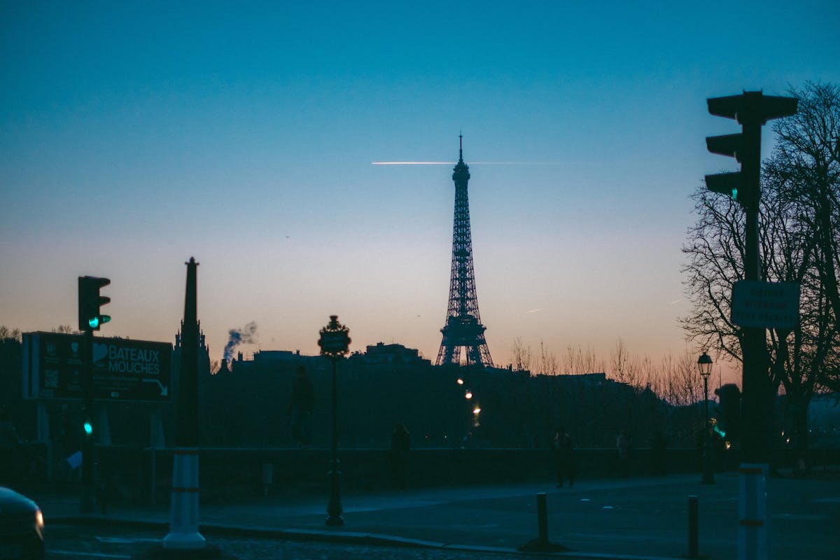Silhouette of the Eiffel Tower at twilight with city lights in Paris