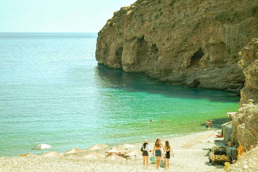 Enchanting summer day at a Greek beach with azure waters and sweeping cliffs.