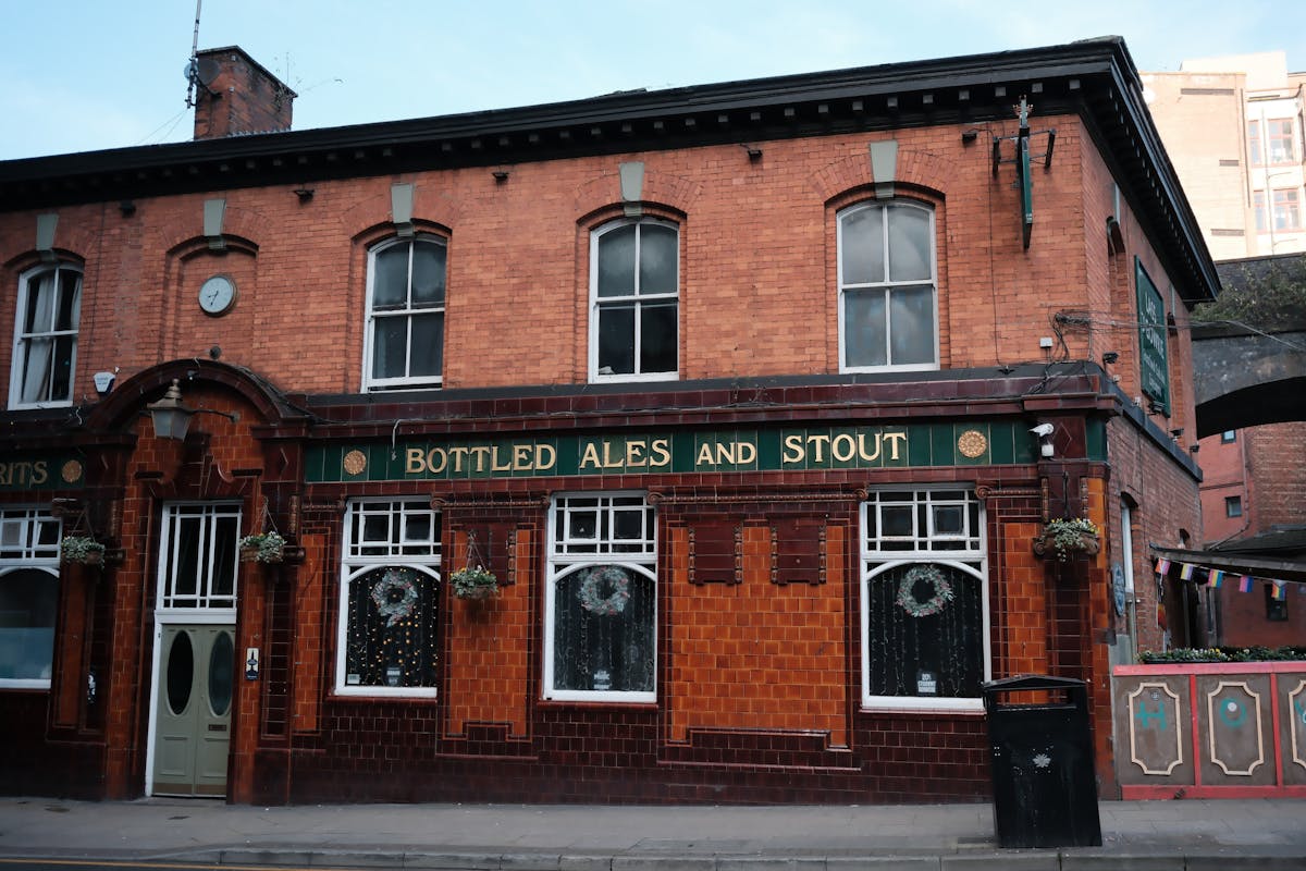 Classic English pub with red brick facade and traditional bottled ales signage