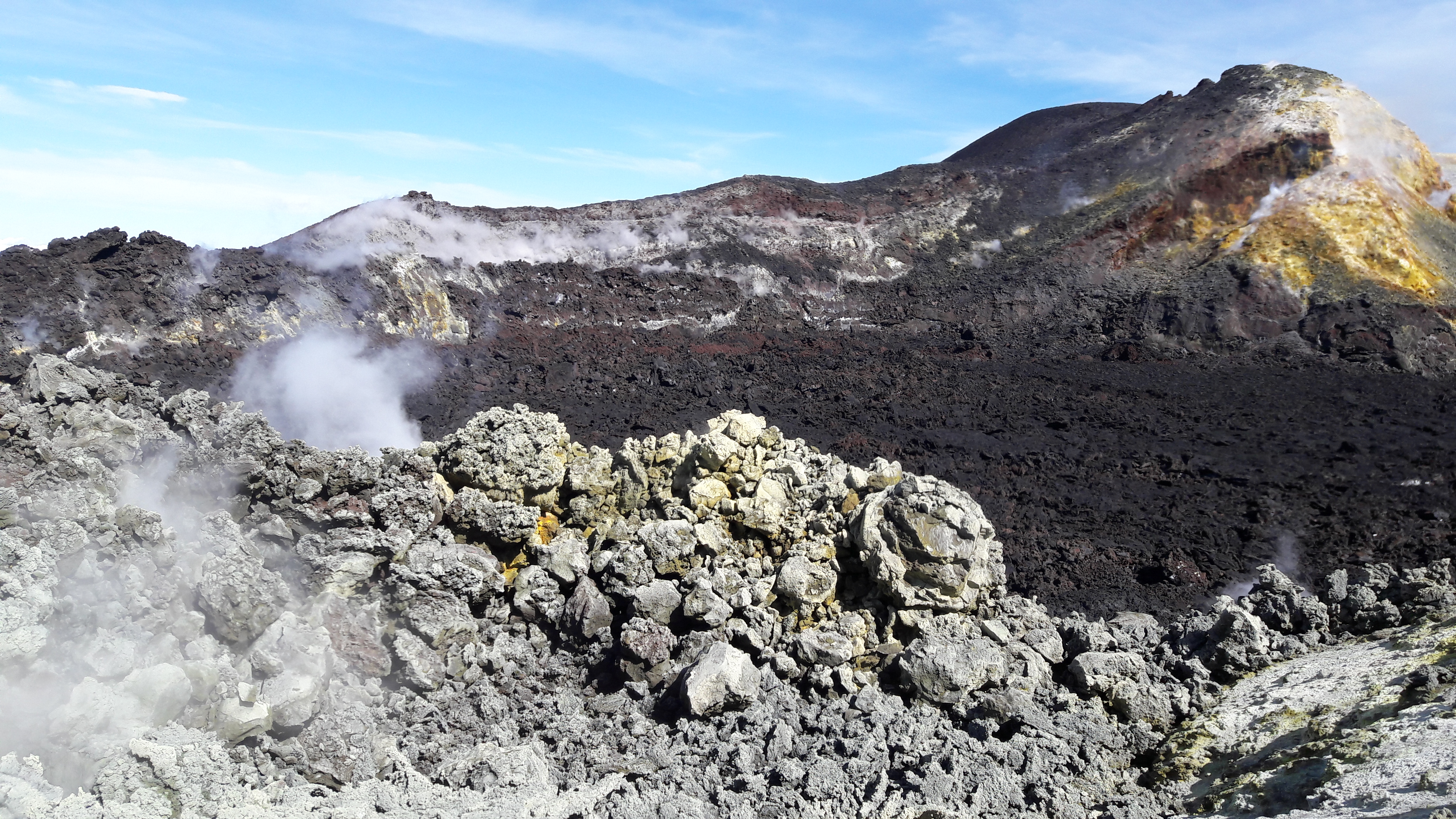 Wide landscape view of Mount Etna rising above green Sicilian countryside