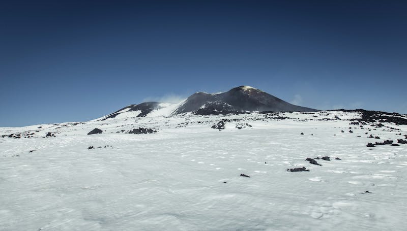 Mount Etna summit covered in snow against a clear blue sky in Sicily