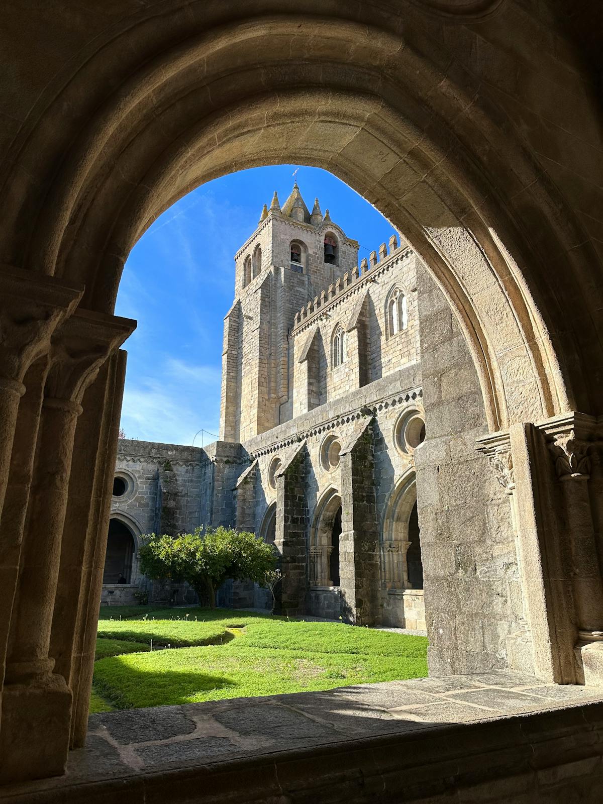 Gothic courtyard and cloisters of Évora Cathedral in warm sunlight