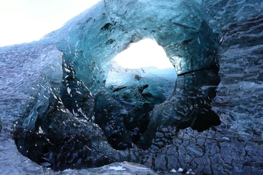 Explore the stunning ice cave with shimmering blue ice in Vatnajökull National Park, Iceland.