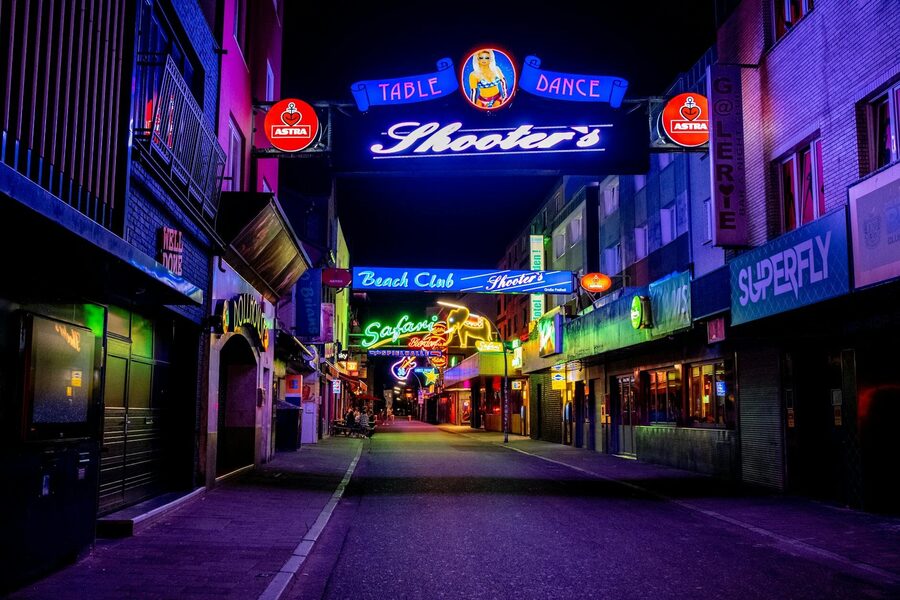 Neon-lit streets of the Reeperbahn district in Hamburg at night with colorful signs