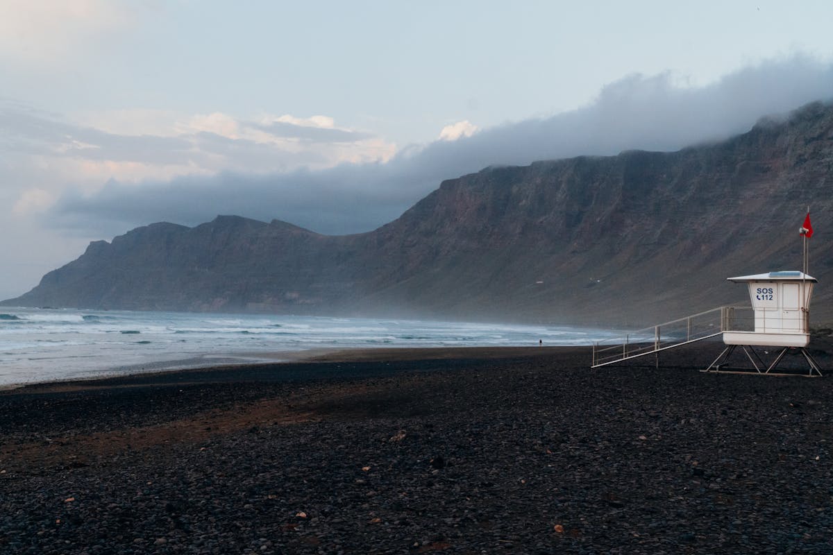 View of Famara Beach in Lanzarote with dramatic cliffs and blue ocean