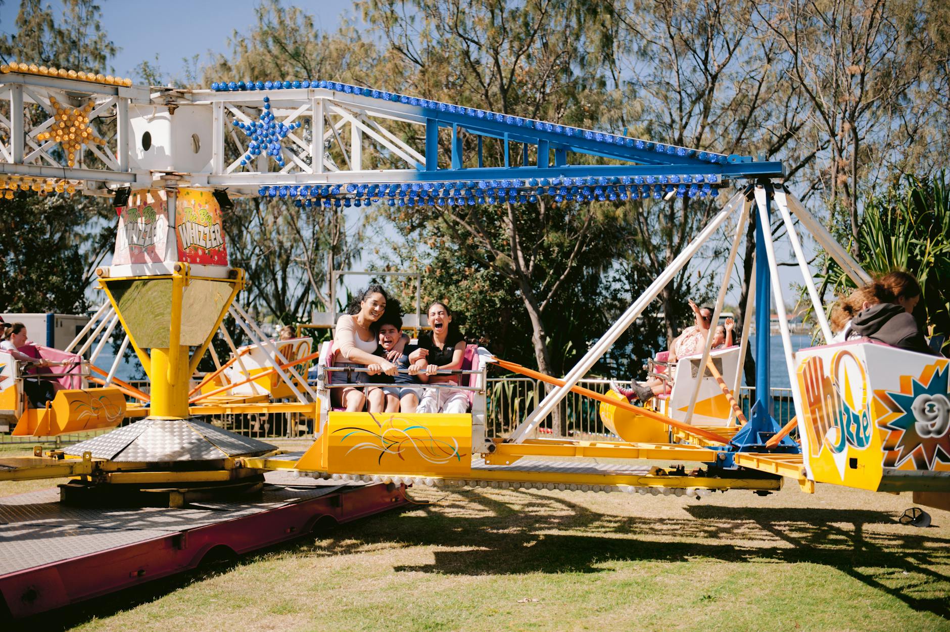 Families enjoying an amusement park ride on a sunny day
