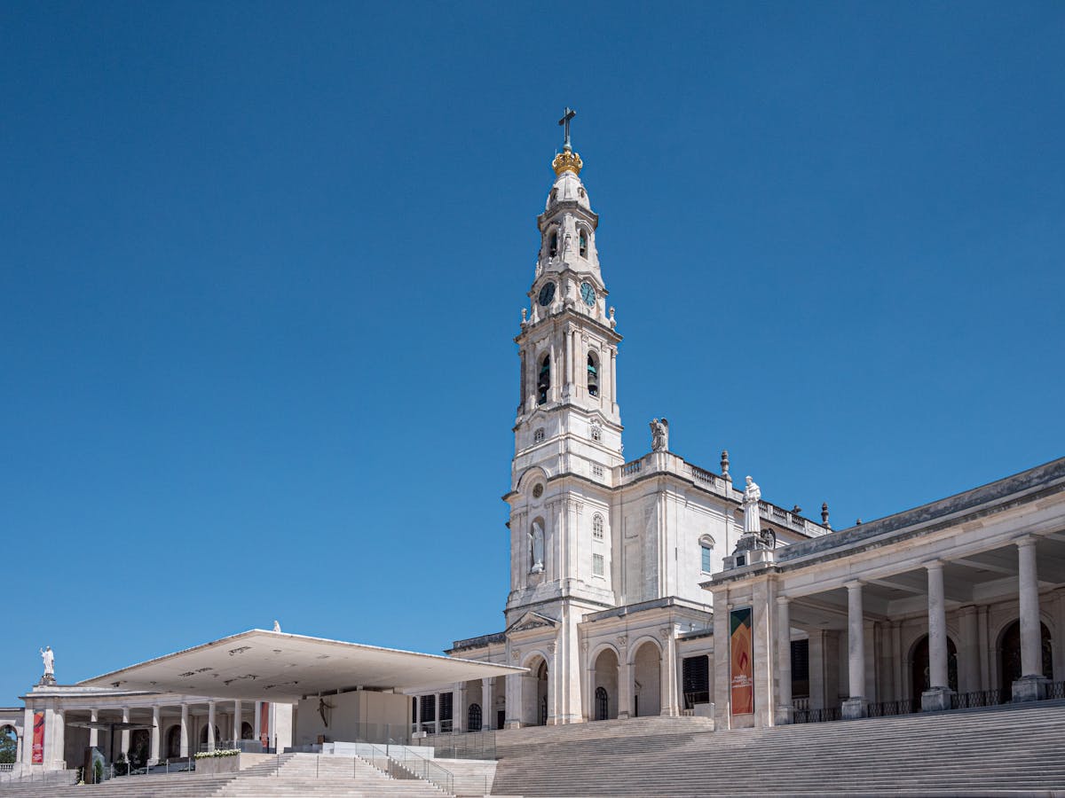 The tower of the Basilica of Our Lady of the Rosary of Fátima against a clear blue sky