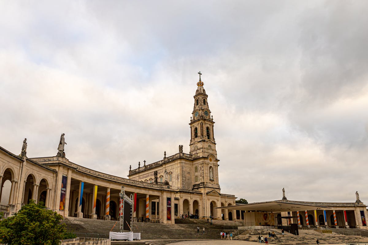 The Sanctuary of Fátima showing its architectural grandeur under dramatic cloudy skies