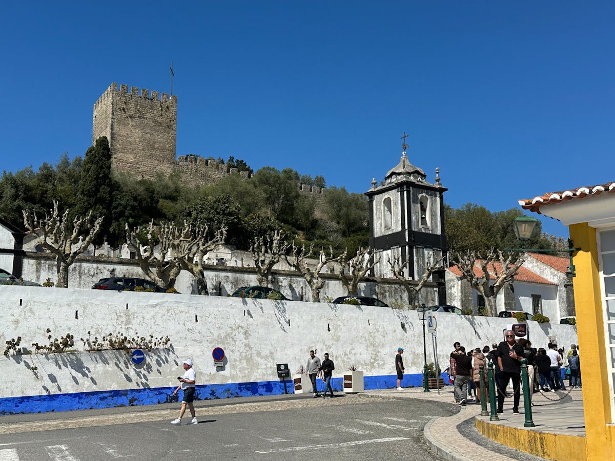 Óbidos Castle tower with a cobblestone street and whitewashed buildings below