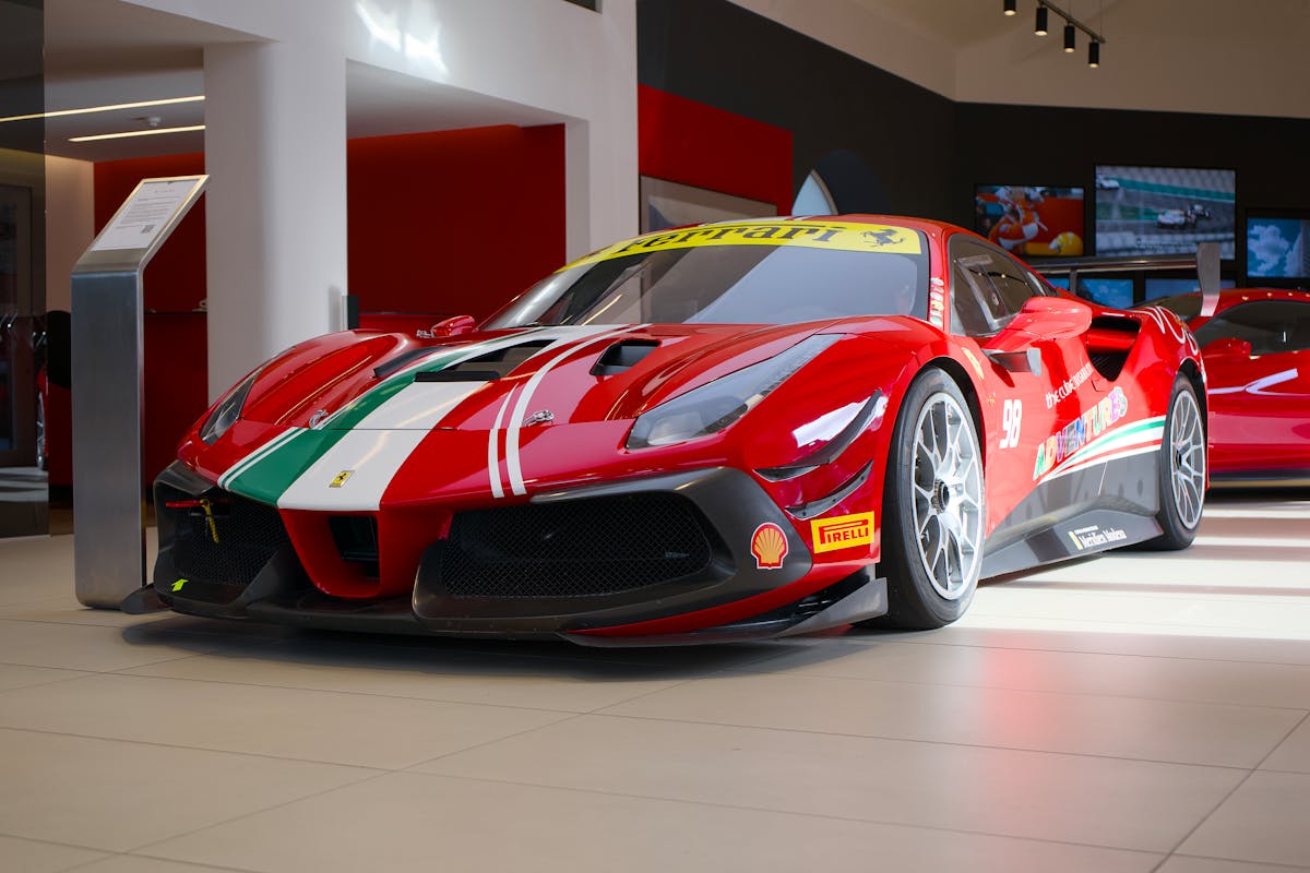 Red Ferrari sports car with racing decals in a showroom display