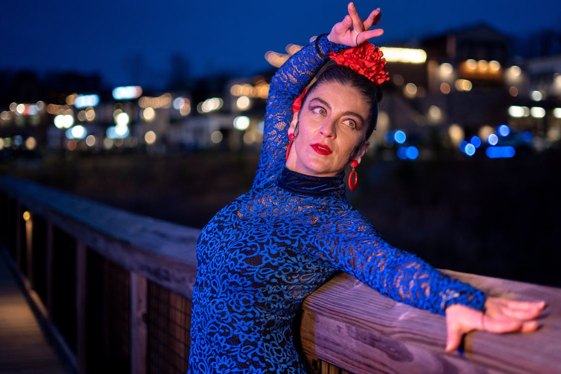 A flamenco dancer in costume posing dramatically at night
