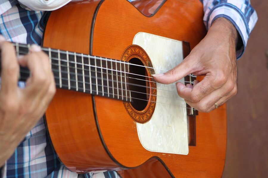 Close-up of a flamenco guitarists hands strumming a wooden guitar during a performance
