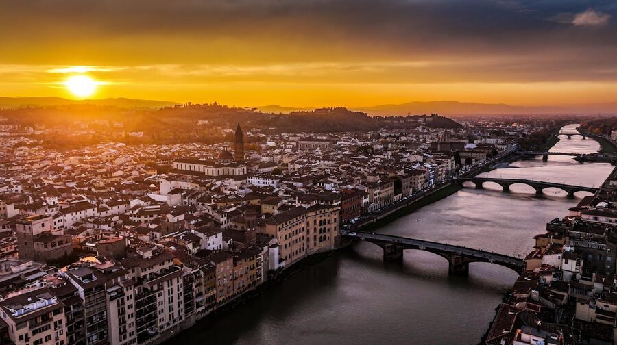 Bird eye view of Florence Italy showing the Arno River winding through the city at sunset