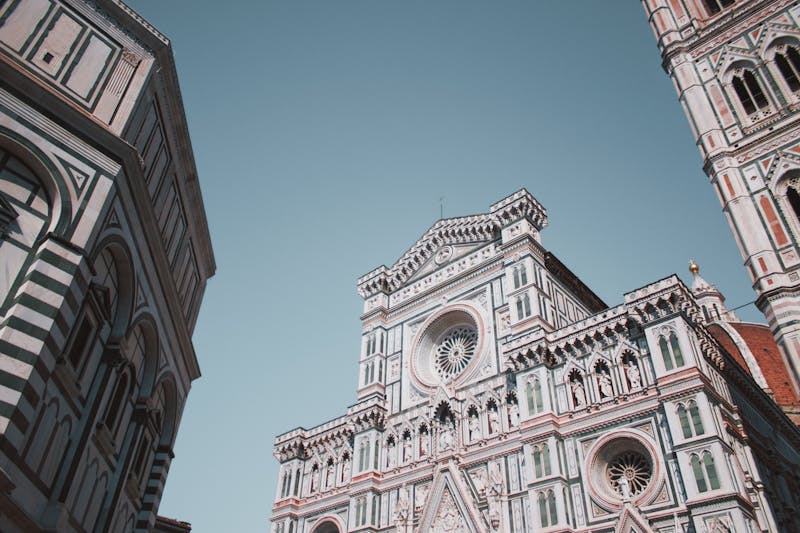 Ornate facade of Florence Cathedral with green and white marble against blue sky