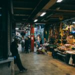 Bustling indoor market scene in Florence Italy with local food vendors and shoppers