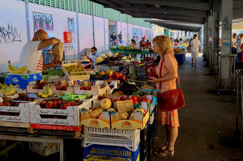 A lively outdoor street market in Florence with fresh produce and local vendors