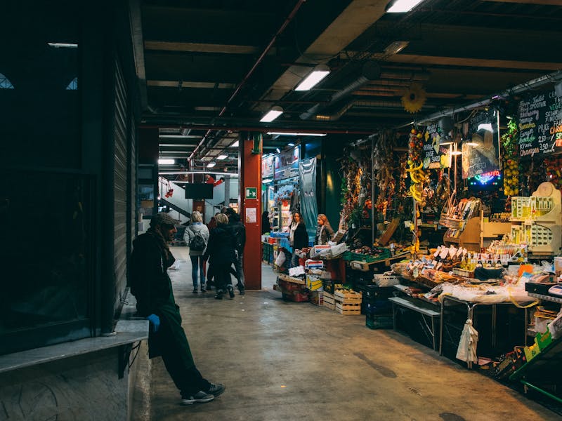 Indoor market in Florence Italy with shoppers browsing local goods