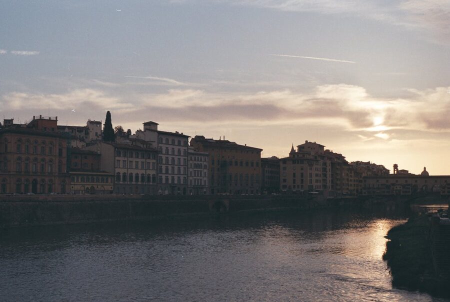 Historic buildings along the Arno River in Florence bathed in warm sunset light