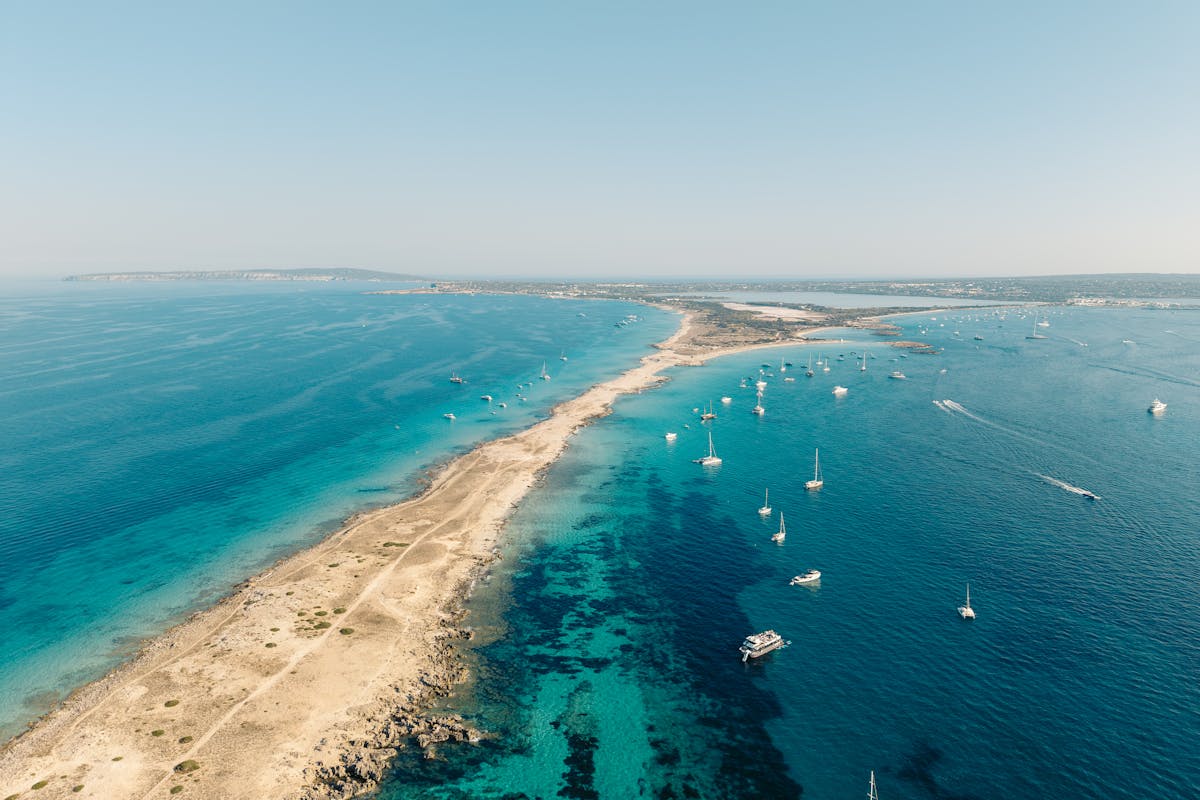 Stunning aerial view of Formentera island coastline with turquoise waters and sailing boats