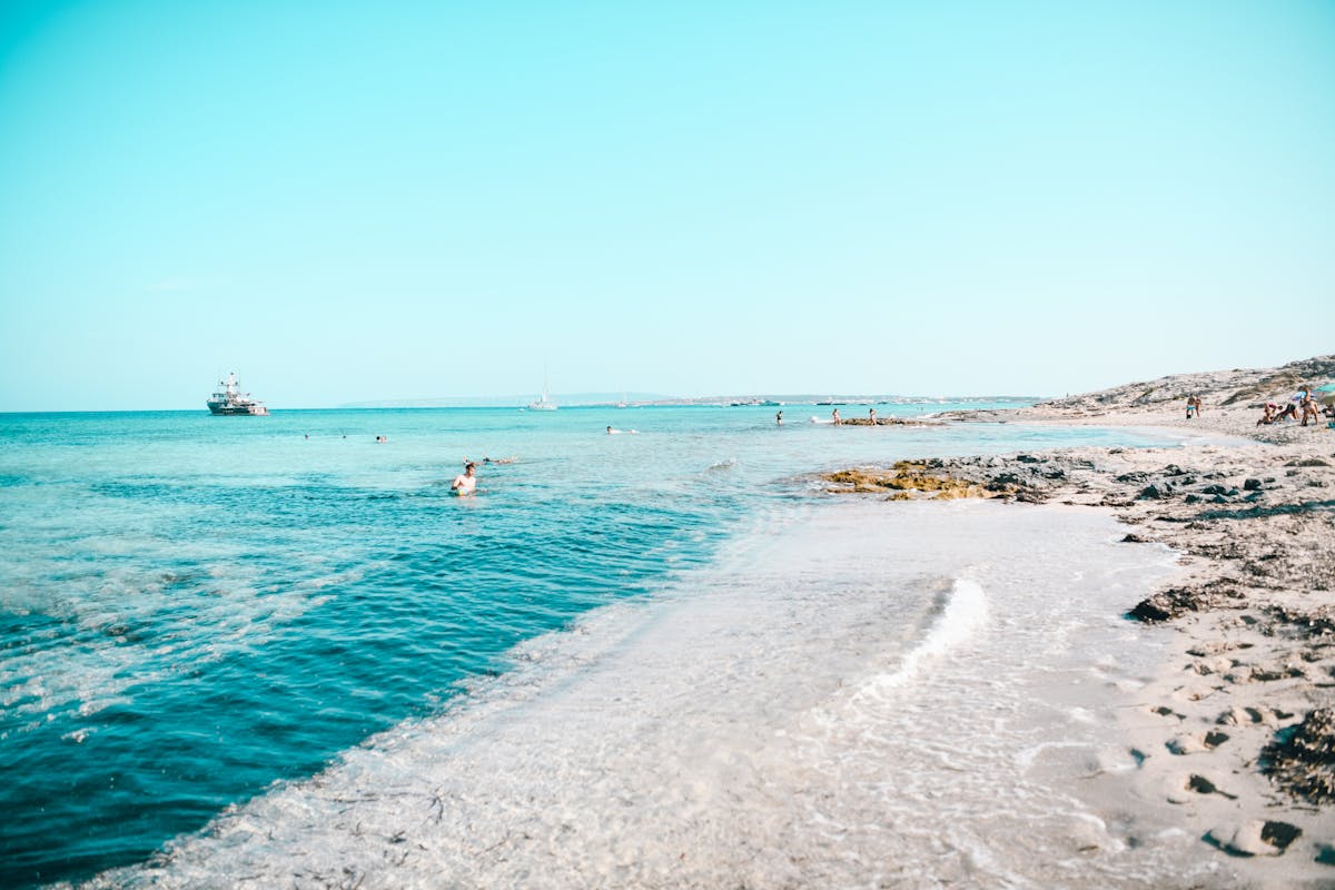 Relaxing beach scene in Formentera, Spain with clear blue water and calm horizon