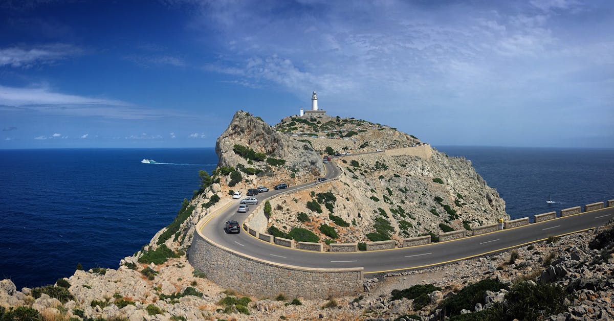 Panoramic view of Cap de Formentor lighthouse with winding road and blue Mediterranean sea