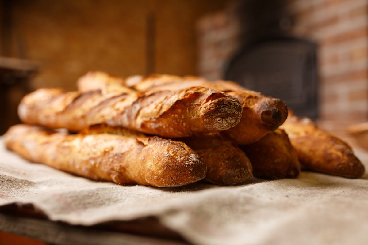 Freshly baked French baguettes lined up at a bakery