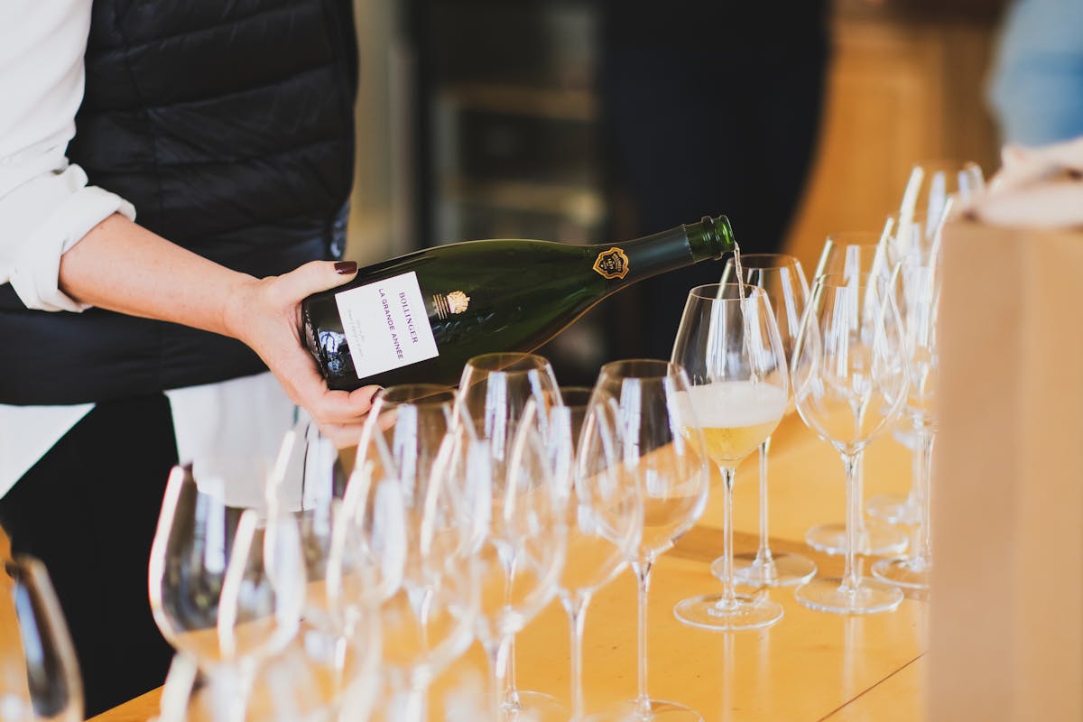 A person pouring champagne at a tasting in the Champagne region of France