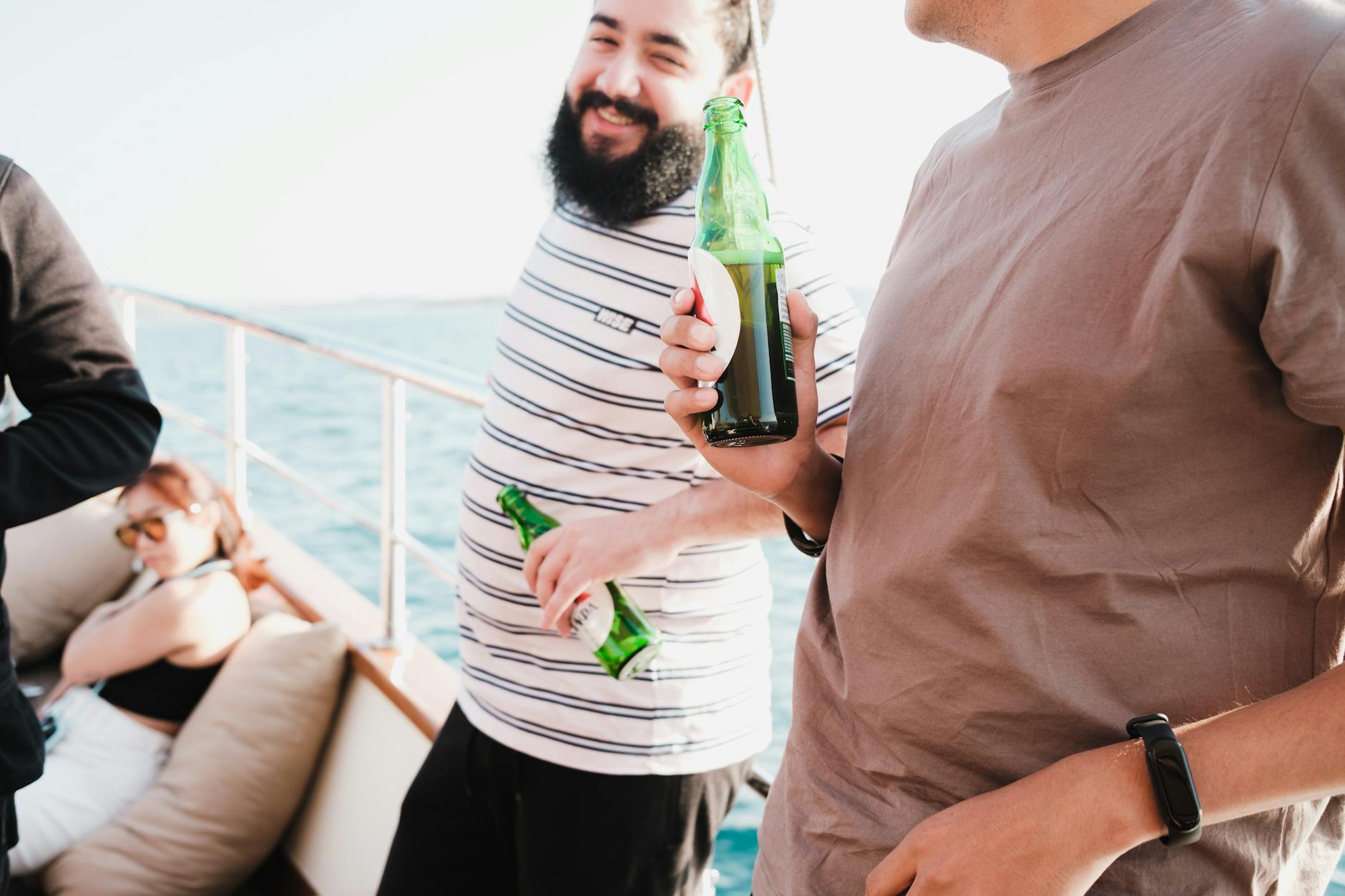 Group of friends drinking beer and socializing on a yacht in summer